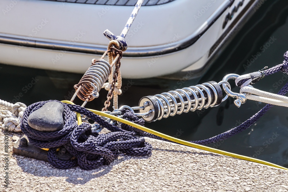 Metal cleat for mooring boats, bolted to the ground, with rope and ...