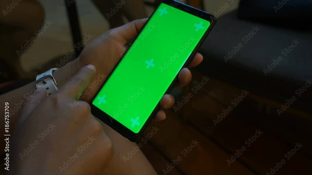 Close up young business women hand touching green screen on smart phone ...