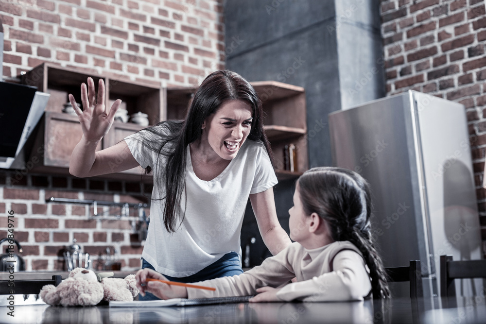 Angry mother. Serious young angry woman looking at her child and ...