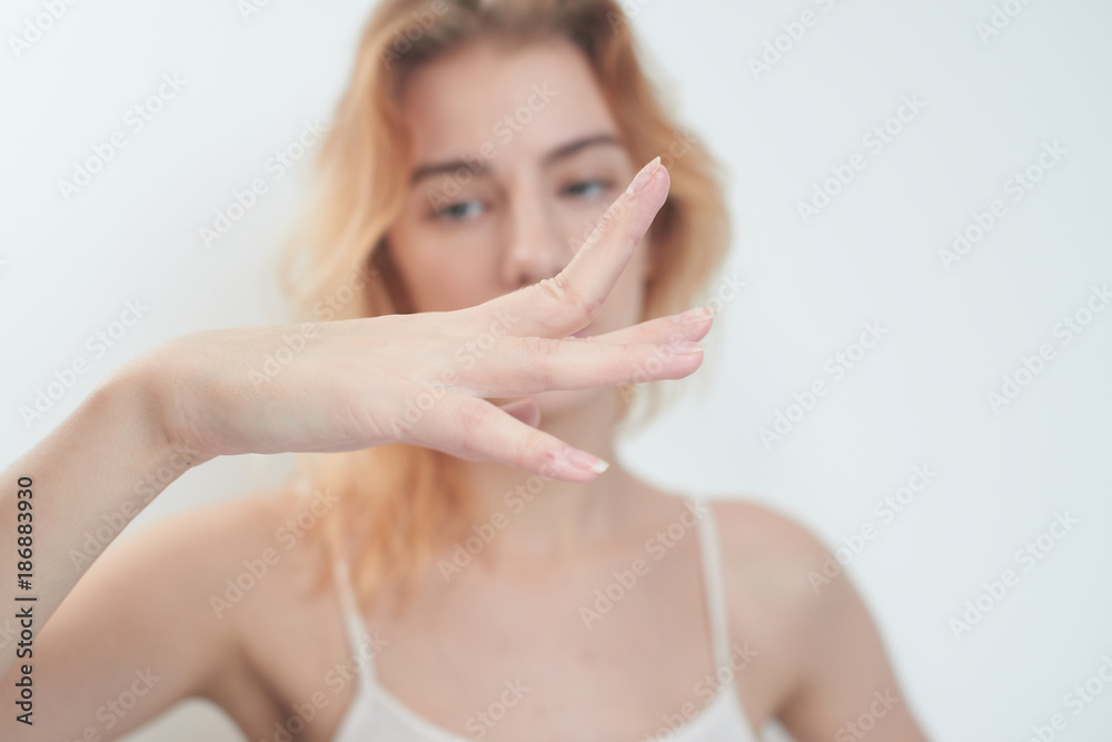 Hypermobility of the joints. The girl flexes the fingers on white ...