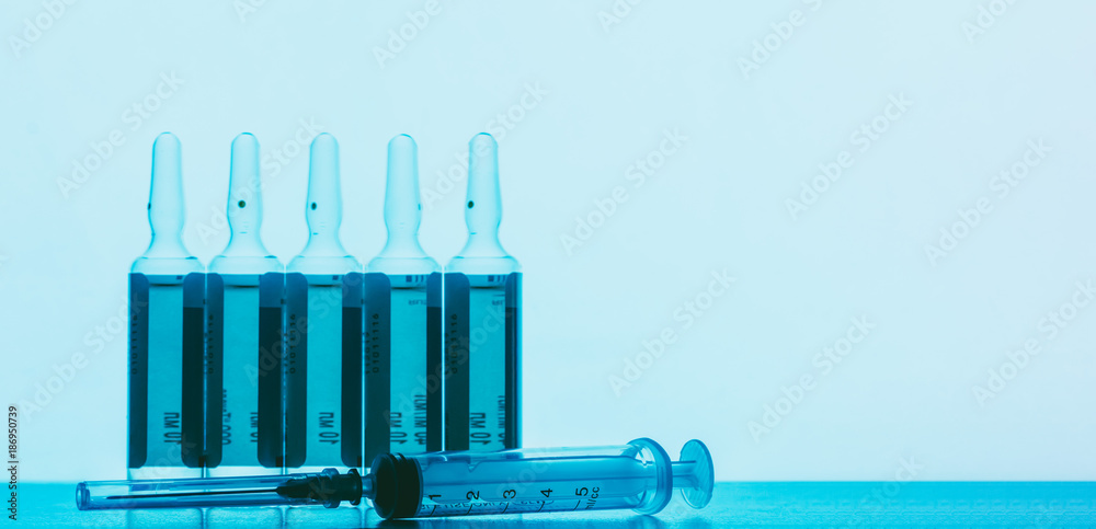 ampoules with a solution for injection and a disposable syringe on a ...