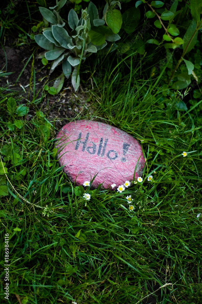 Painted pebble stone with the German word Hallo, meanging hello, as ...