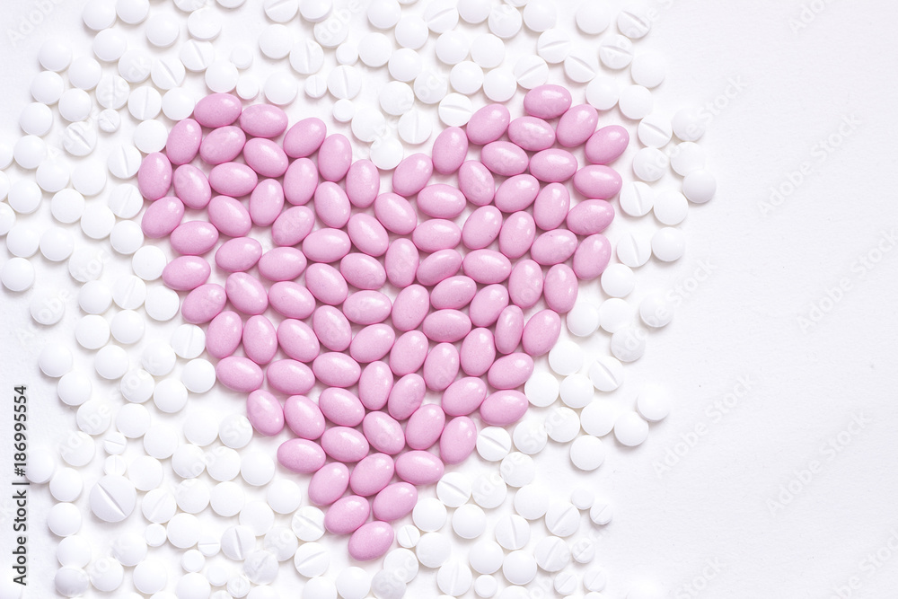 Foto Stock Pink heart shaped of pills in between white tablets | Adobe ...