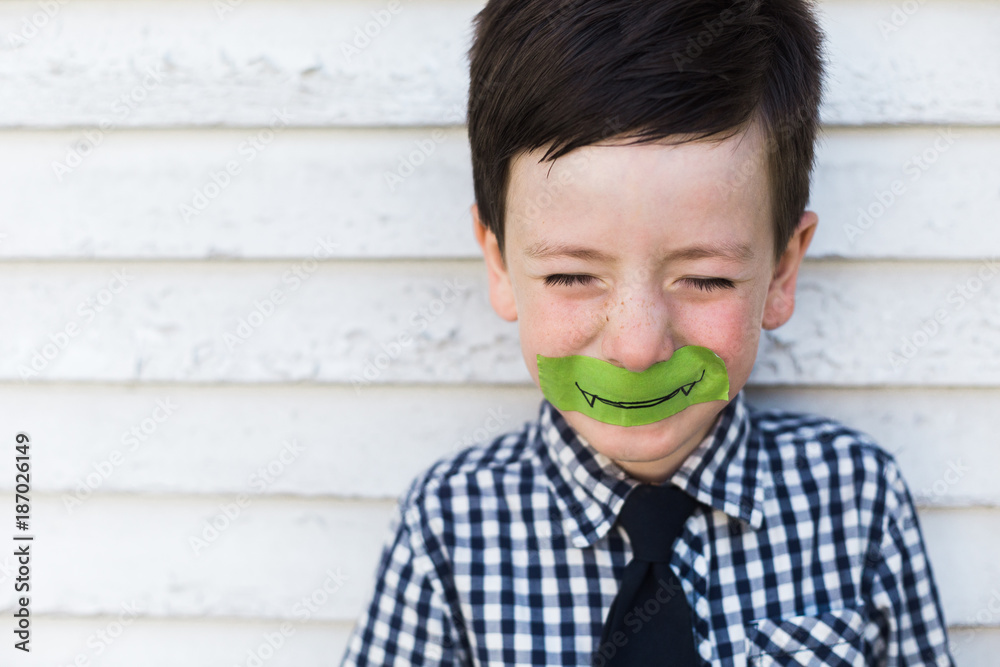 Little boy with a monster smile taped on his face Stock Photo | Adobe Stock