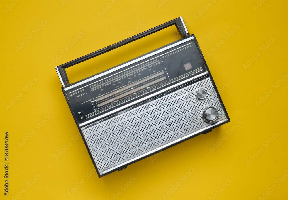 Top view of a retro radio receiver on a yellow background. Culture of ...