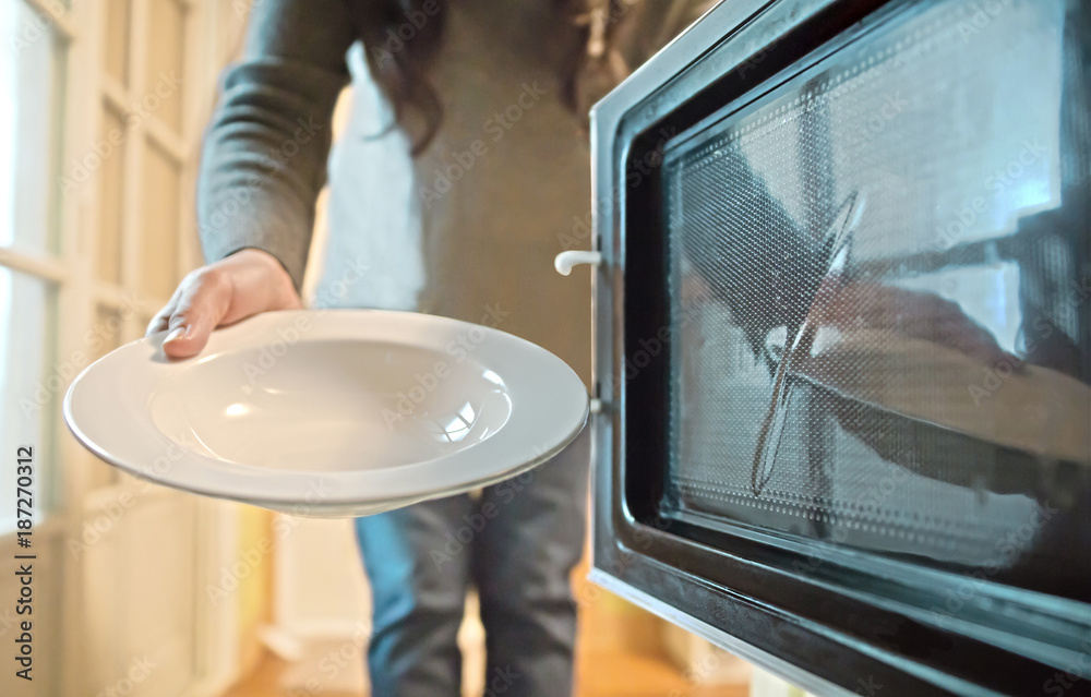 Housewife looking at dish into oven in kitchen. View from inside of the ...