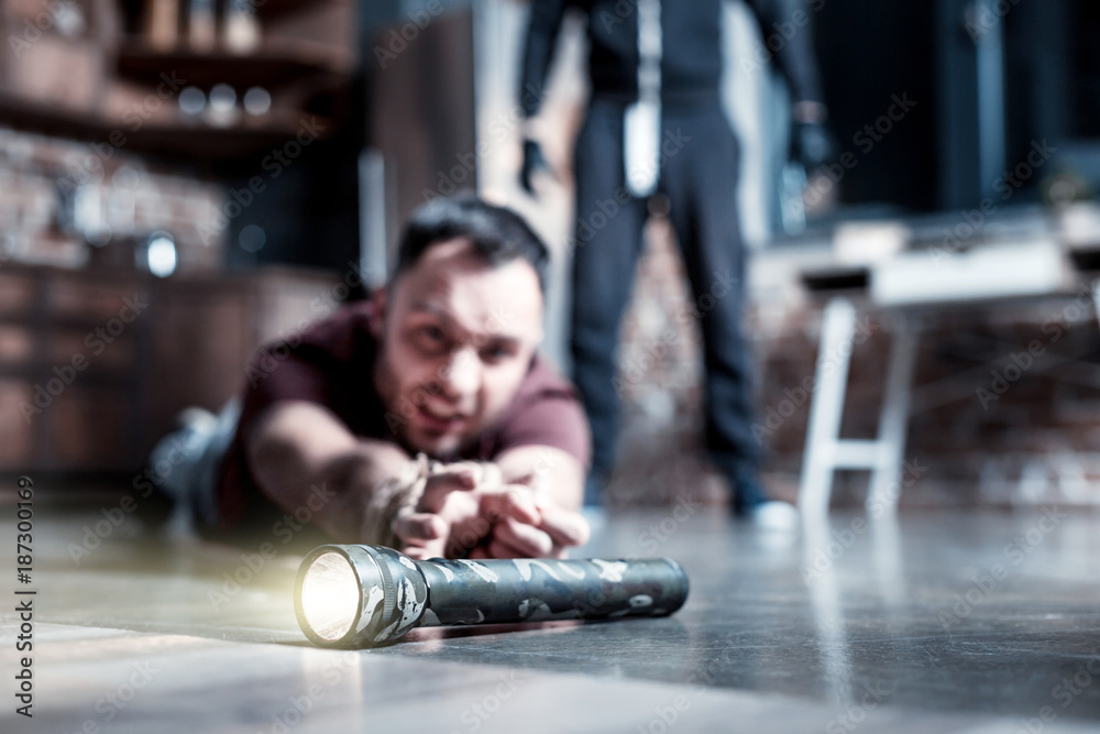 Lying on floor. Scared panic bearded man lying on the floor and having ...