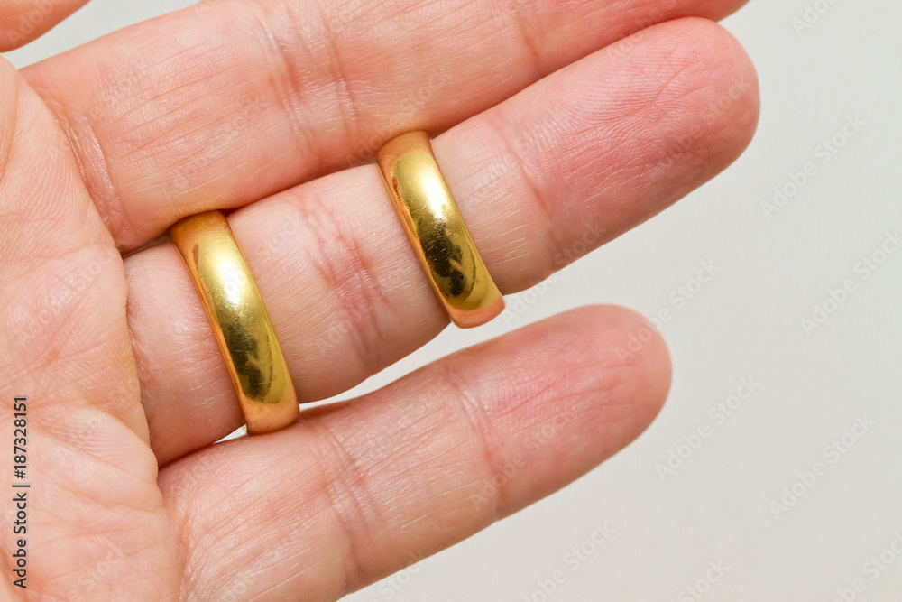 Zwei Eheringe am Finger foto de Stock | Adobe Stock