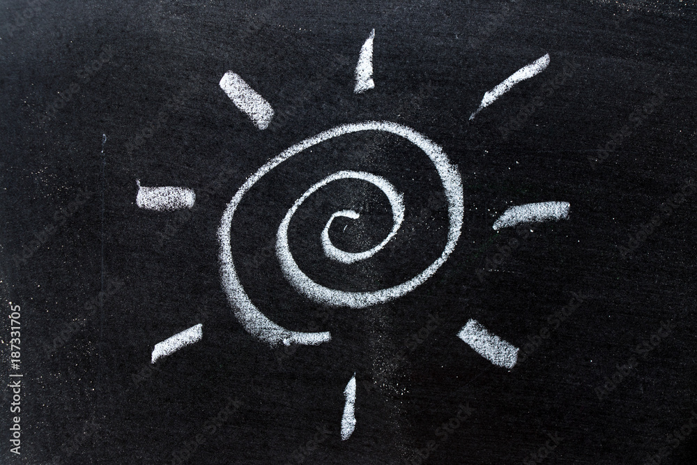 White color chalk hand drawing as sun with light ray shape on black ...