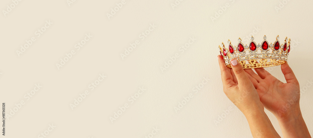 Woman's hand holding a crown for show victory or winning first place ...