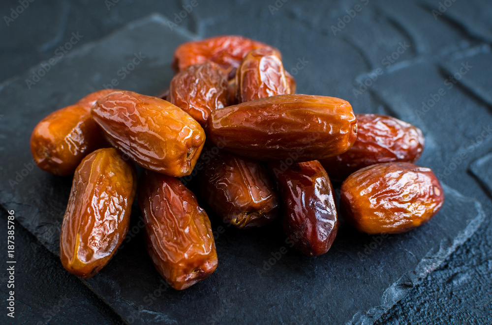 Dried dates on black stone background Stock Photo | Adobe Stock