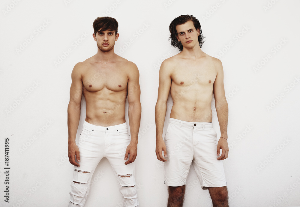 Two male models posing against white wall Stock Photo | Adobe Stock