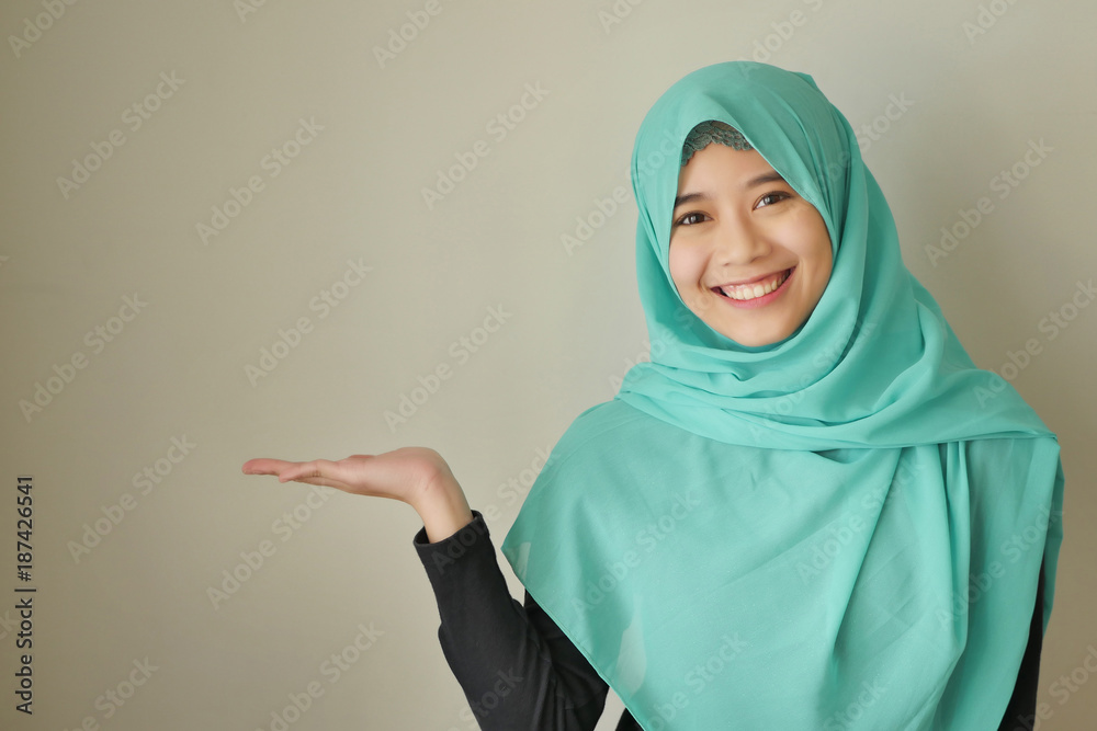 muslim woman pointing hand up to blank space Stock Photo | Adobe Stock