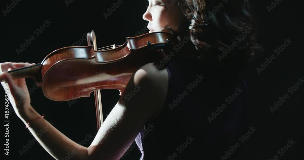 Vidéo Stock Violinist girl performing on stage, light, dark background ...