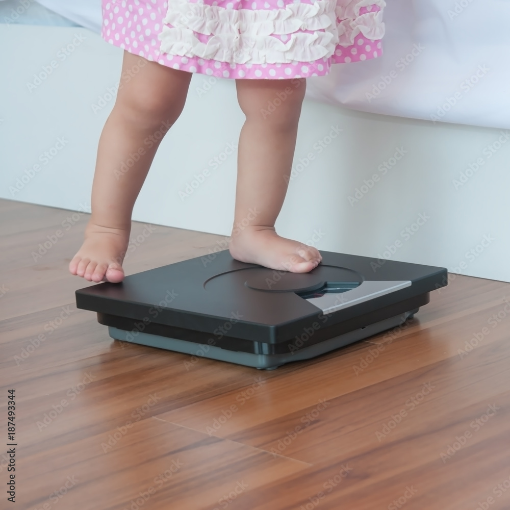 Cute child 1 year and 2 months step up on personal Weight Scale in ...