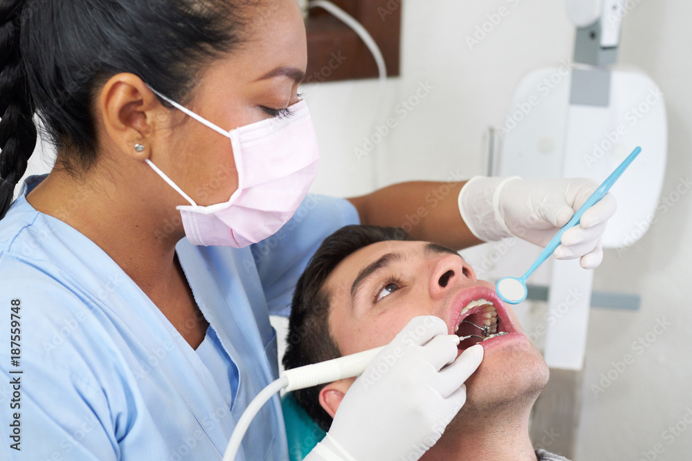 Dentist checking teeth of a male patient Stock Photo | Adobe Stock