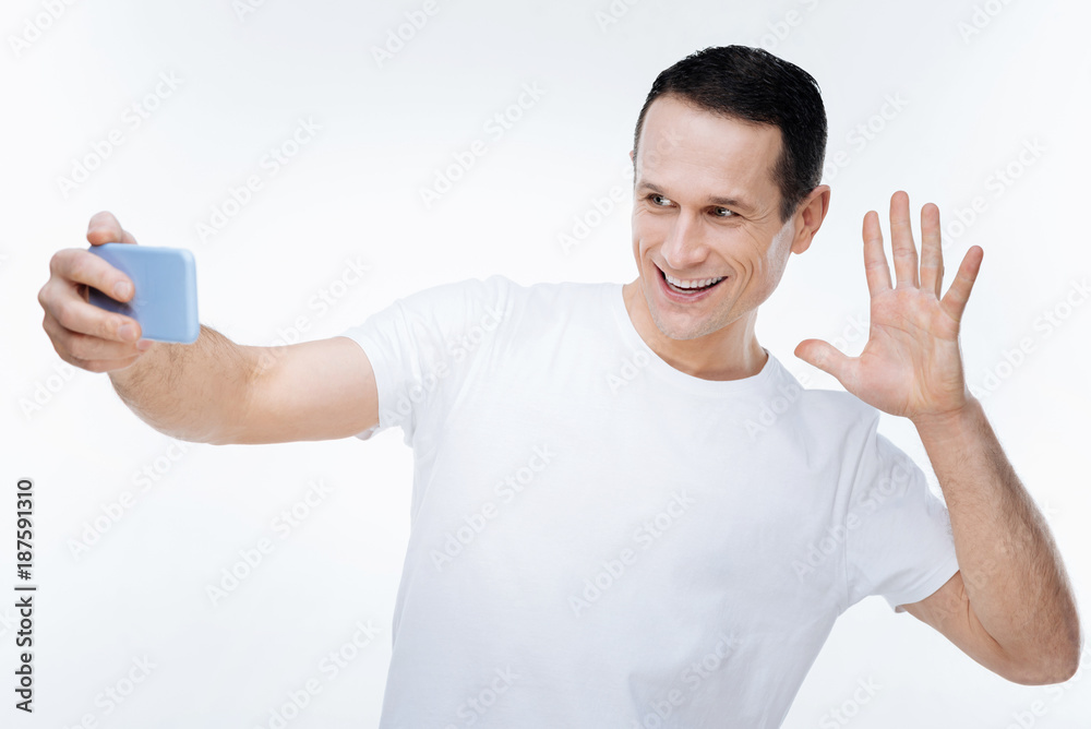 Time for selfies. Happy cheerful nice man smiling and showing his hand ...