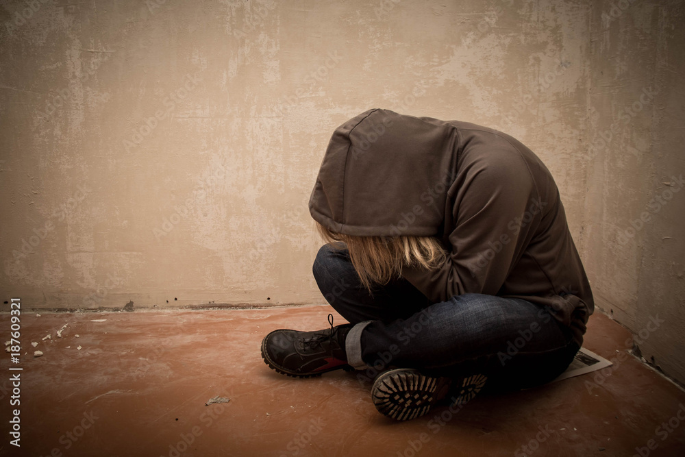 Portrait of man sad, drug addict man sitting on the floor in corner ...