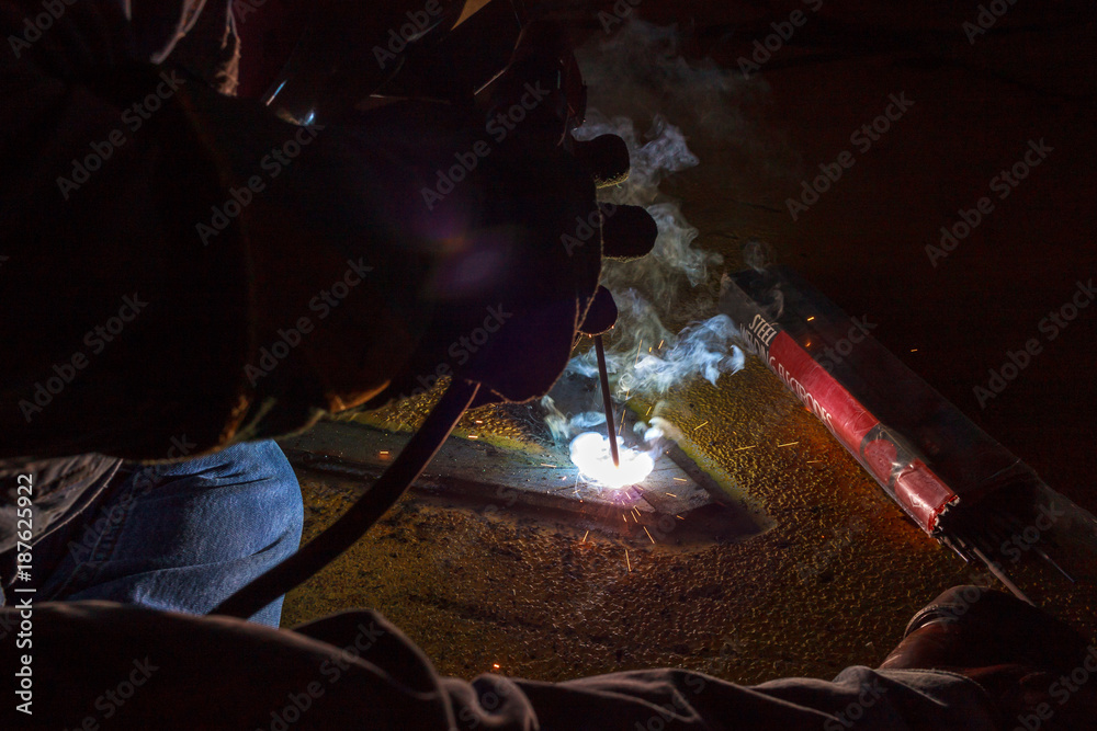 Welder perform welding to the metal plate at roof floor of ...