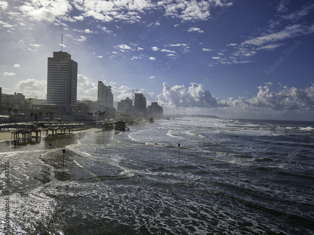 Tel-Aviv seaside view. Surfers enjoy the sea surf. Modern hotels on ...