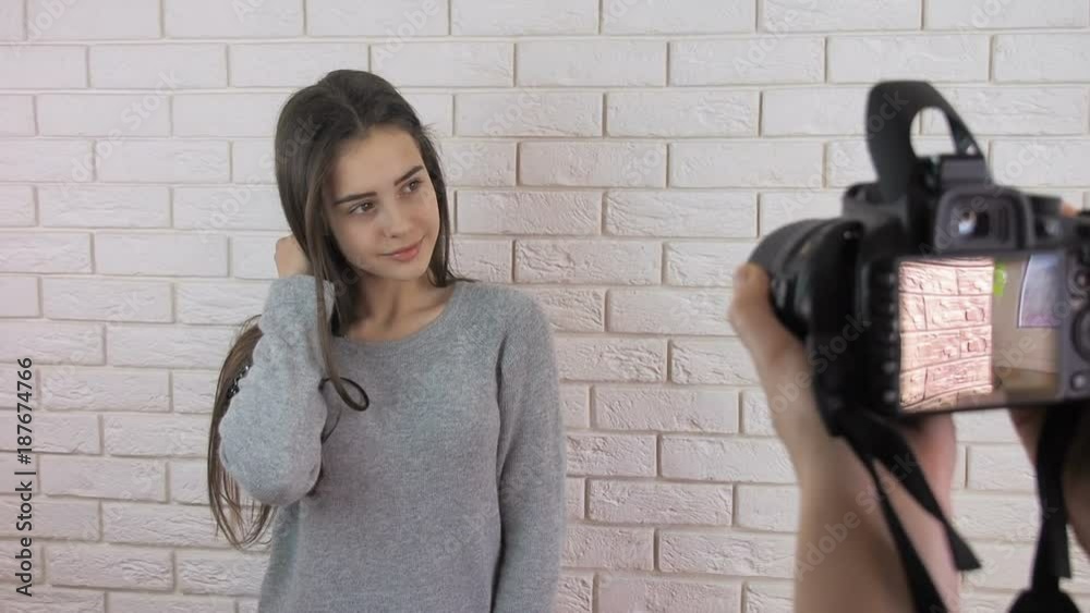 The photographer takes a picture of the model. A beautiful girl is ...