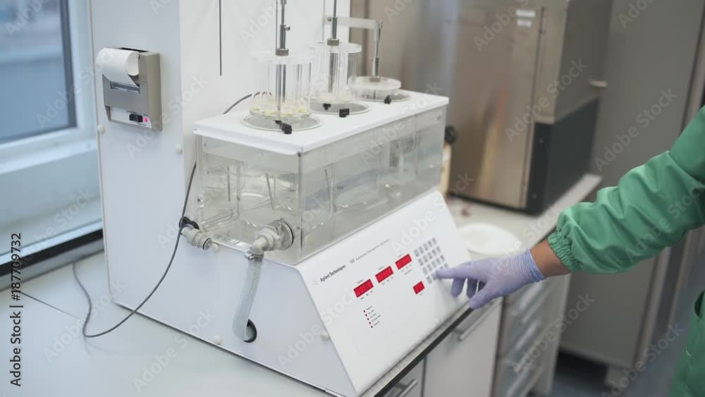 Laboratory assistant manages the medical machine for mixes liquid ...
