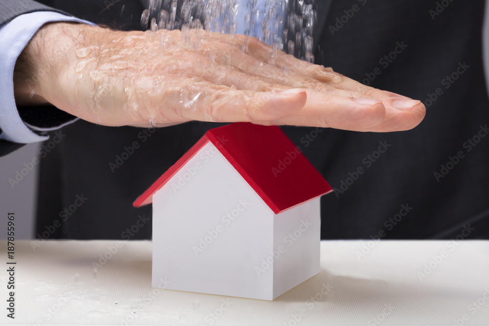 Hand Over The House Model From Falling Water Stock Photo | Adobe Stock