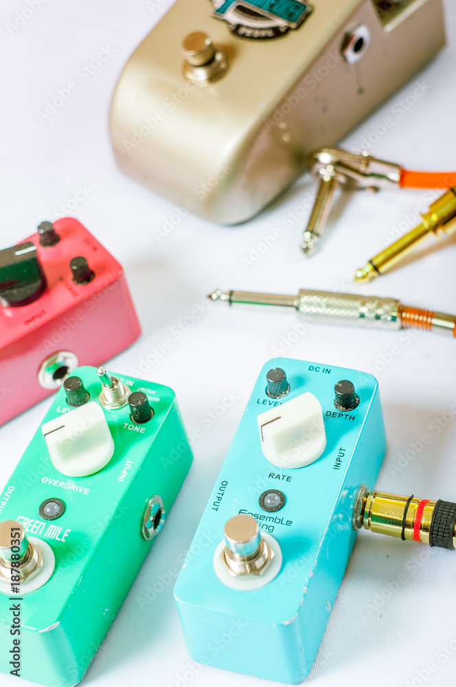 Electric guitar stomp effectors and cables in studio. Focus is on ...