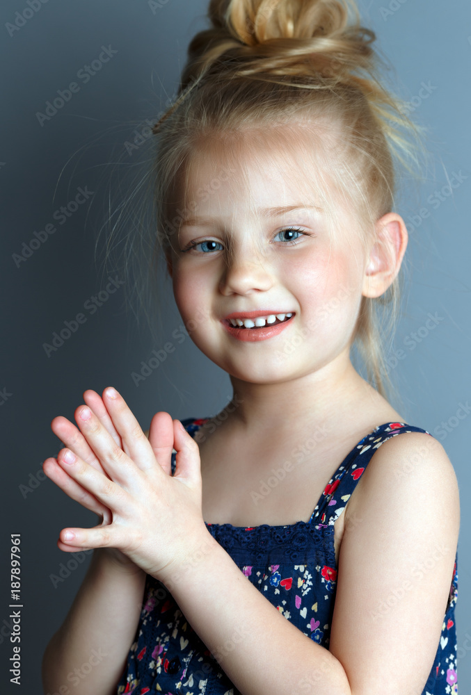 Portrait of a happy, positive, smiling, little girl, grey background ...