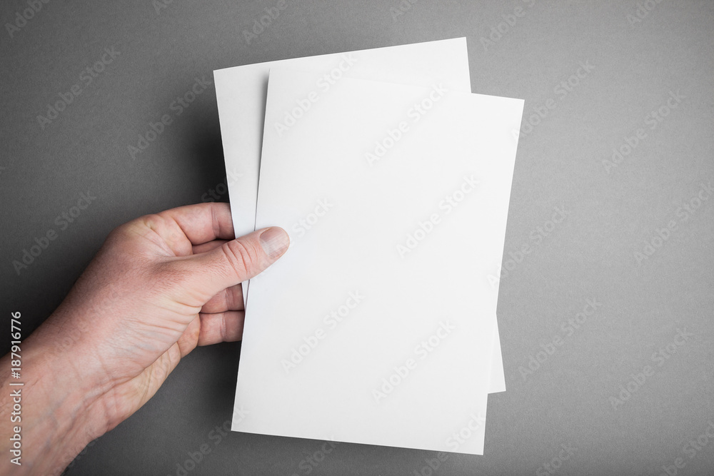 Hand holding white blank paper A5 sheet mockup. Leaflet document ...