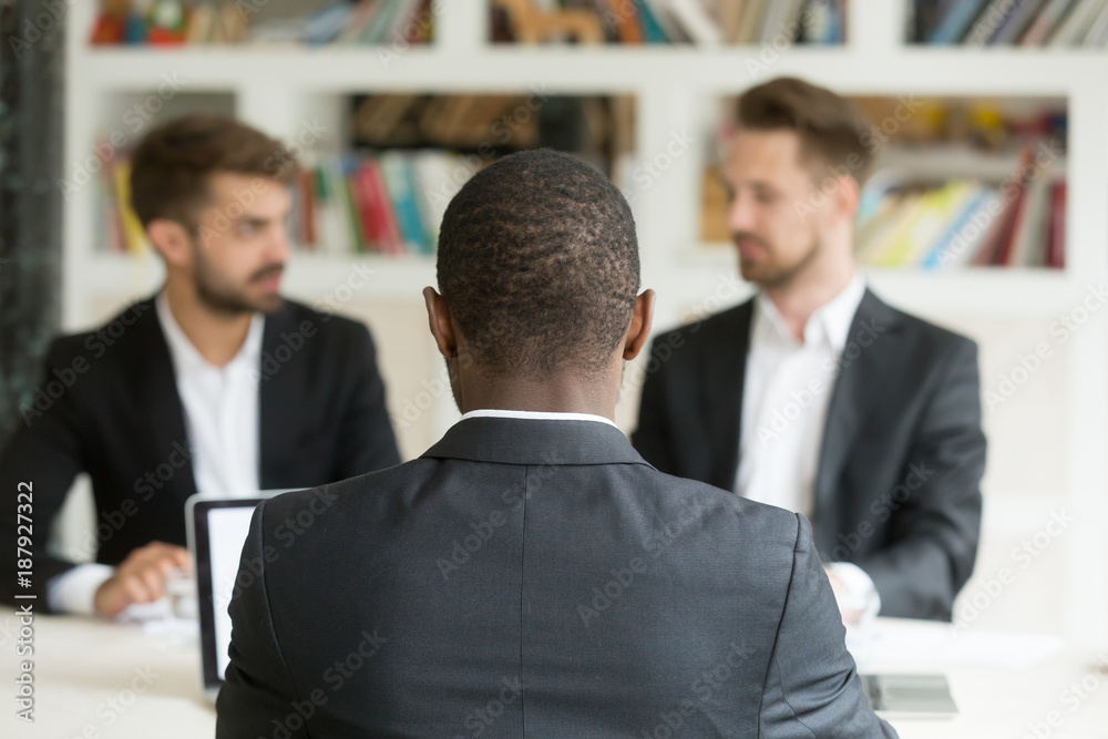Rear view at african businessman against two caucasian men wearing ...