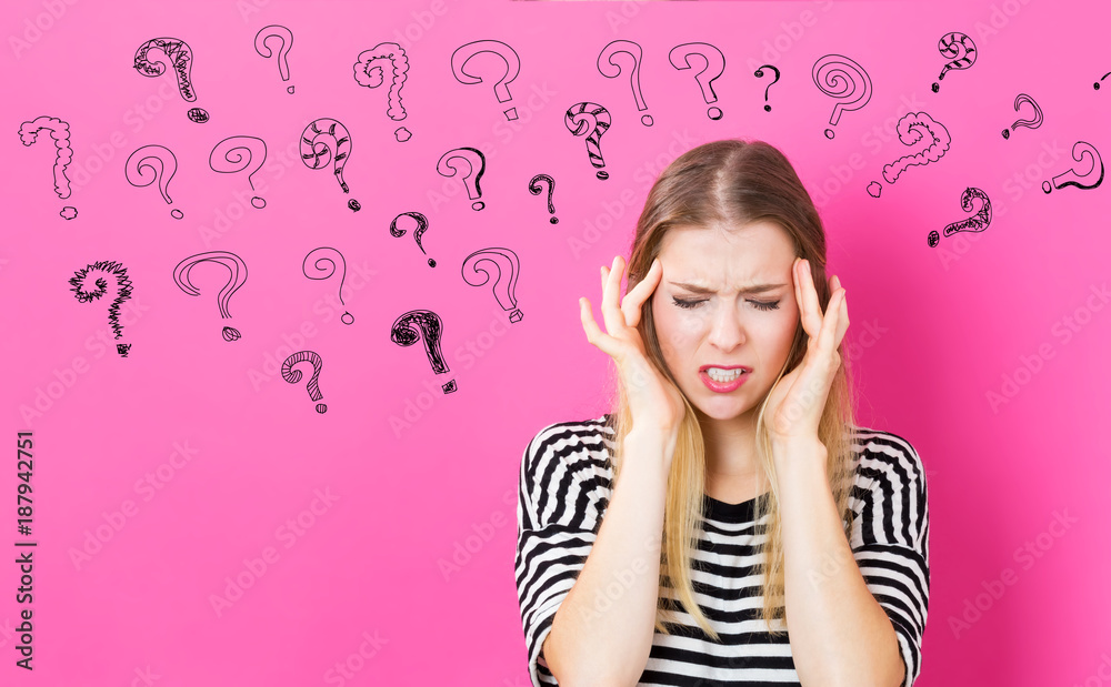 Question Marks with young woman feeling stressed on a pink background ...
