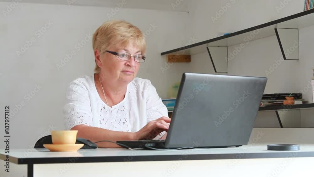 elderly woman in glasses works at home on laptop Stock Video | Adobe Stock