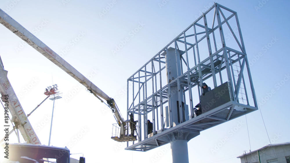 Builder on a Lift Platform at a construction site. Men at work ...