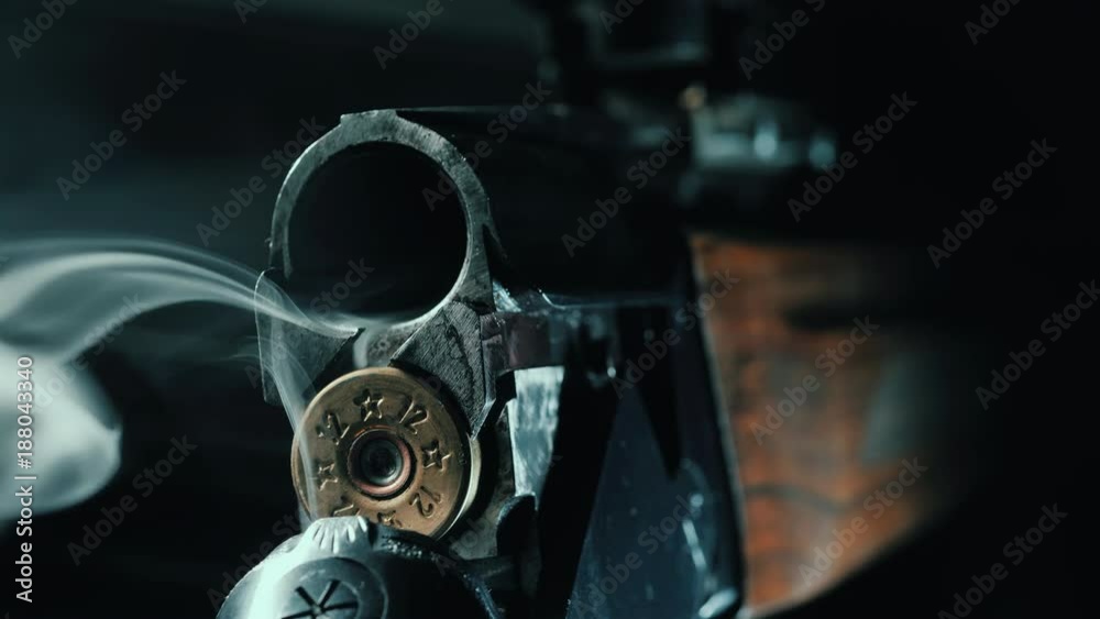 Smoking Barrel of rifle. Shotgun shells being removed from shotgun with ...