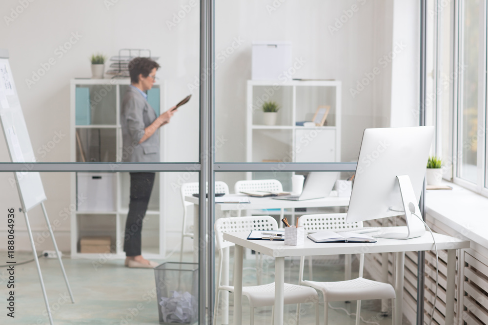 Transparent office wall between two rooms with busy manager reading ...