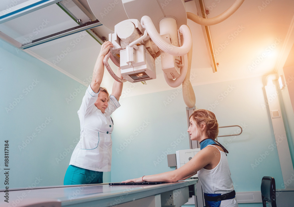 Radiologist and patient in a x-ray room. Classic ceiling-mounted x-ray ...
