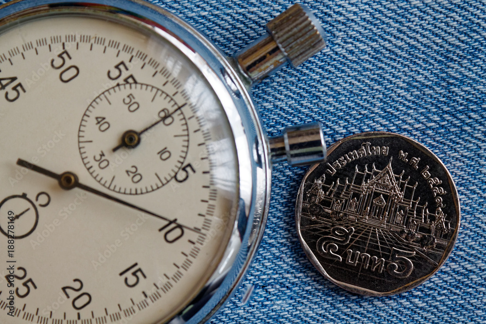 Thai coin with a denomination of 5 baht (back side) and stopwatch on ...