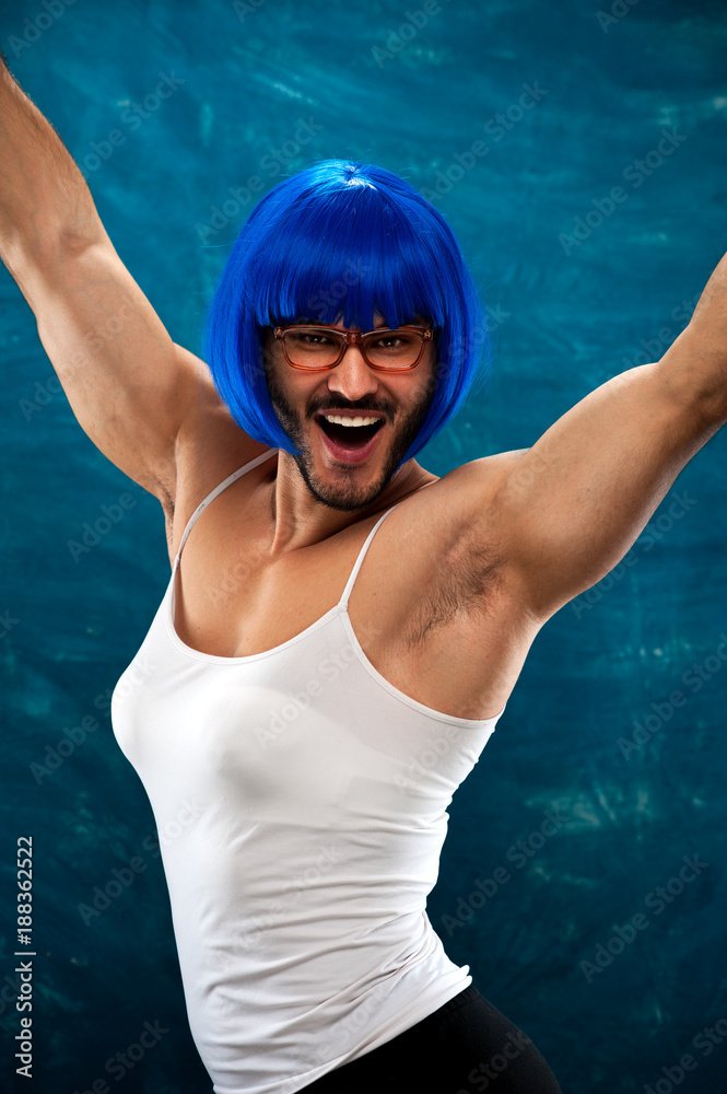 Cheerful young male cross dressing person raising his hands and posing ...