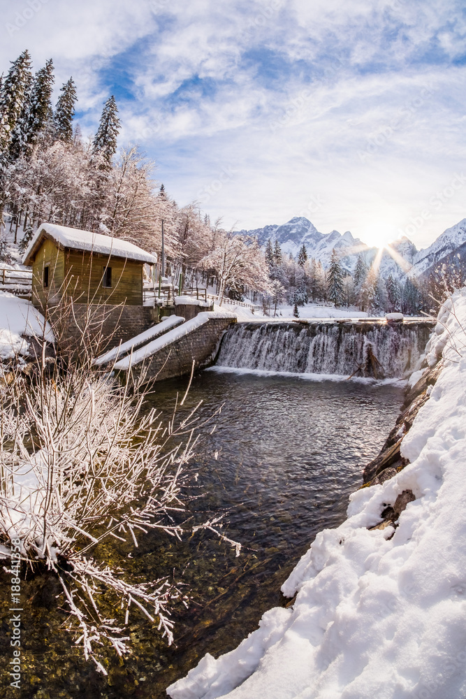 Water from lake Fusine flows over dam in river Stock Photo | Adobe Stock