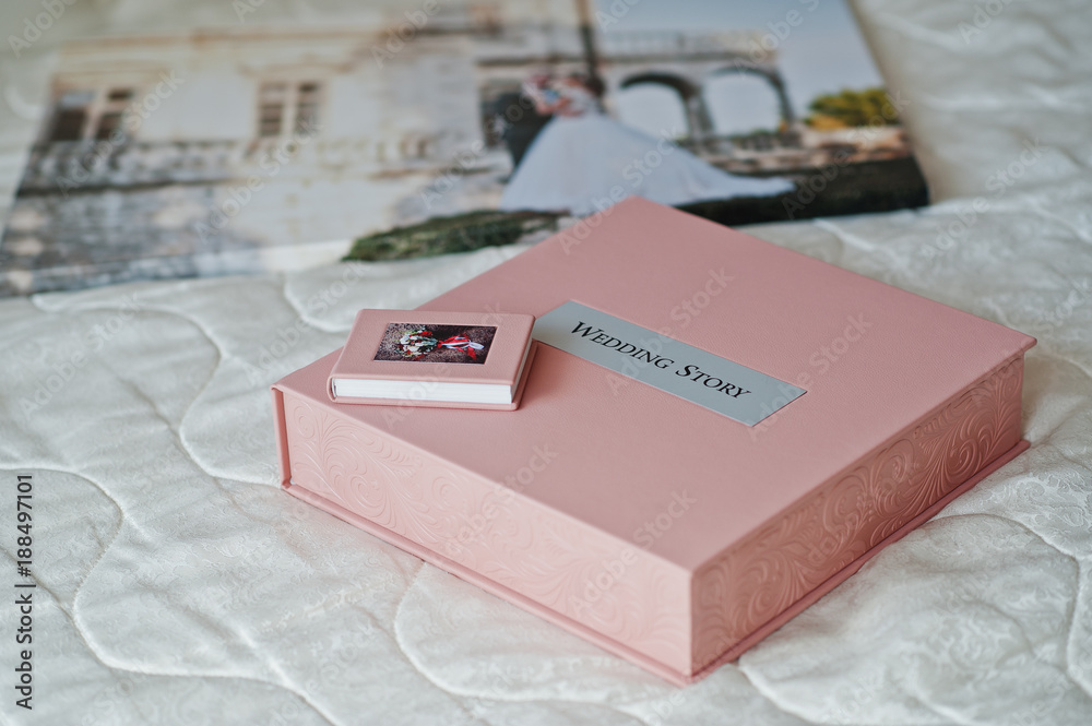 Gentle pink wedding photobook or photo album, box, and cd case laying ...