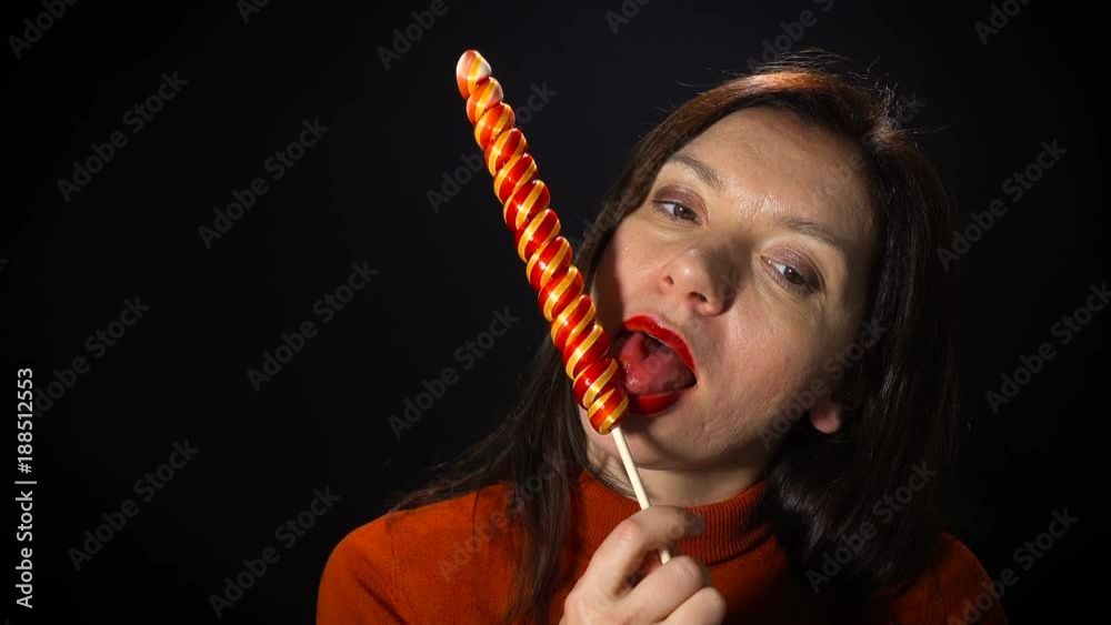 Beautiful woman sucks lollipop. Stock Video | Adobe Stock