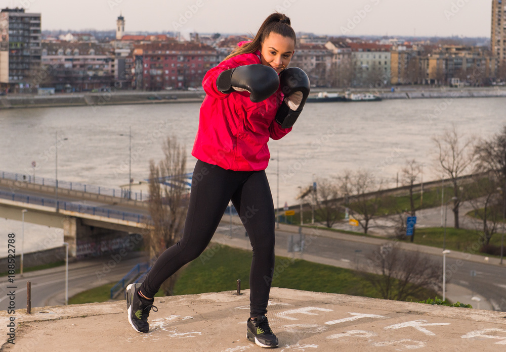 Young girl wearing boxing gloves throwing a punch - martial arts ...