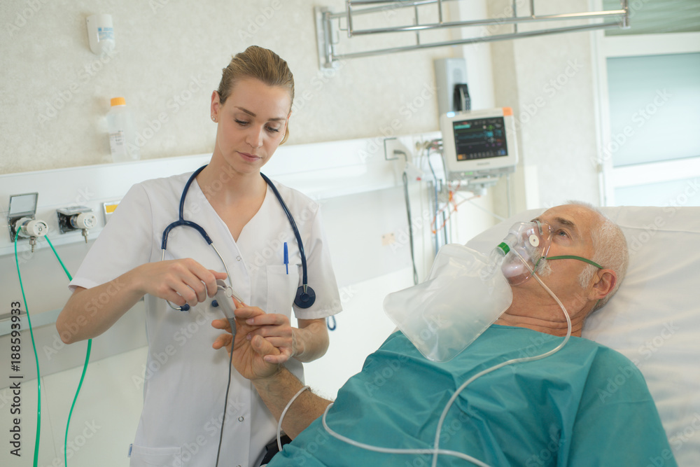 Nurse attaching pulse monitor to elderly patient Stock Photo | Adobe Stock
