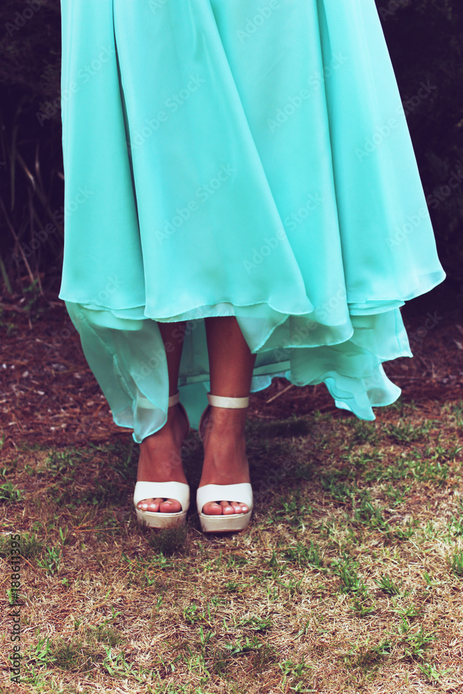 Portrait of the feet of a young woman wearing a formal dress and high ...