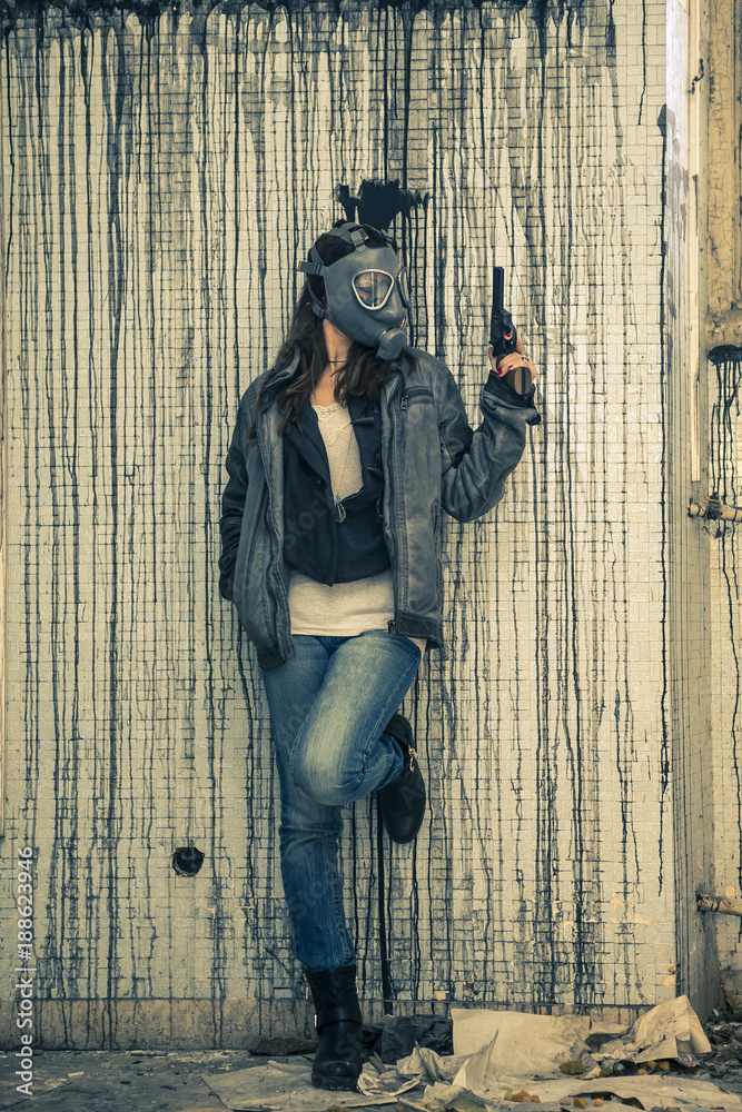 Biochemical warfare survivor, armed with a gun and a gas mask, standing ...