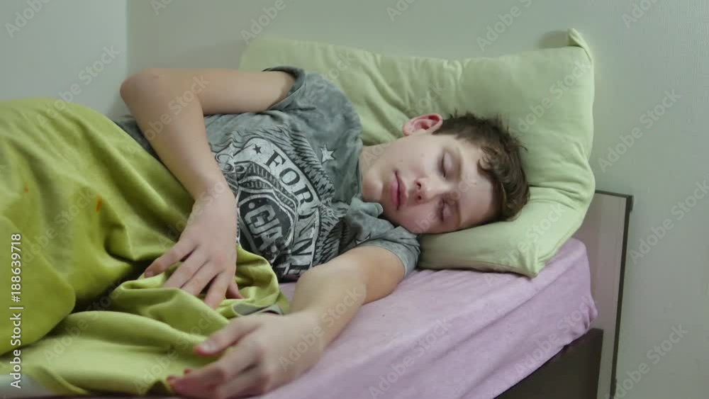 Teenage boy asleep in indoors bed. man tired shaggy teenage boy ...