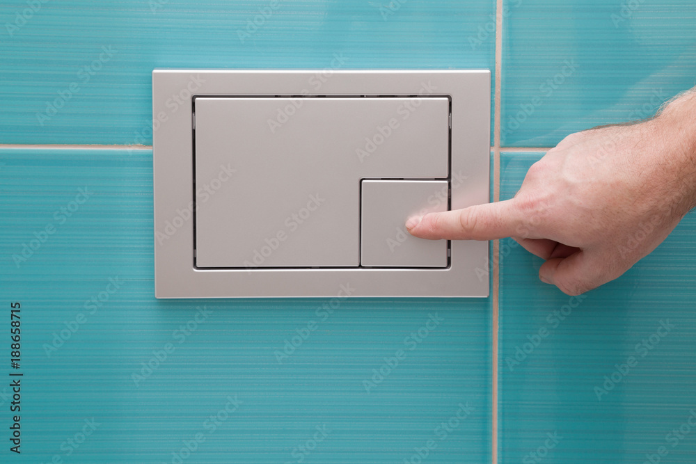 Foto Stock Man's hand pressing a button in the wc. Modern economic ...