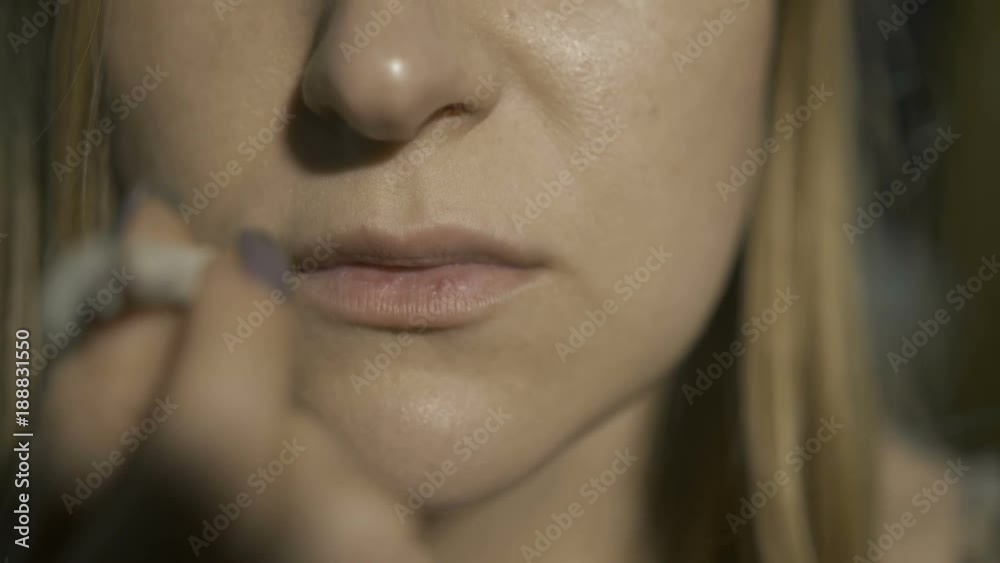 Extreme close-up of female's face with nose and mouth smoking marijuana ...