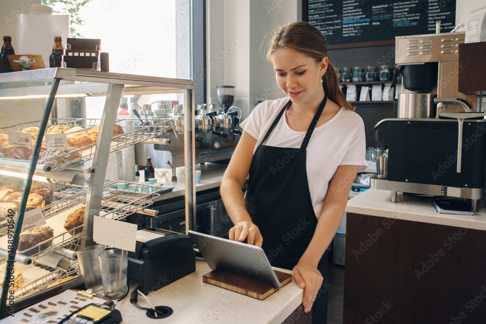 Portrait of young caucasian female woman cashier. Seller using touch ...